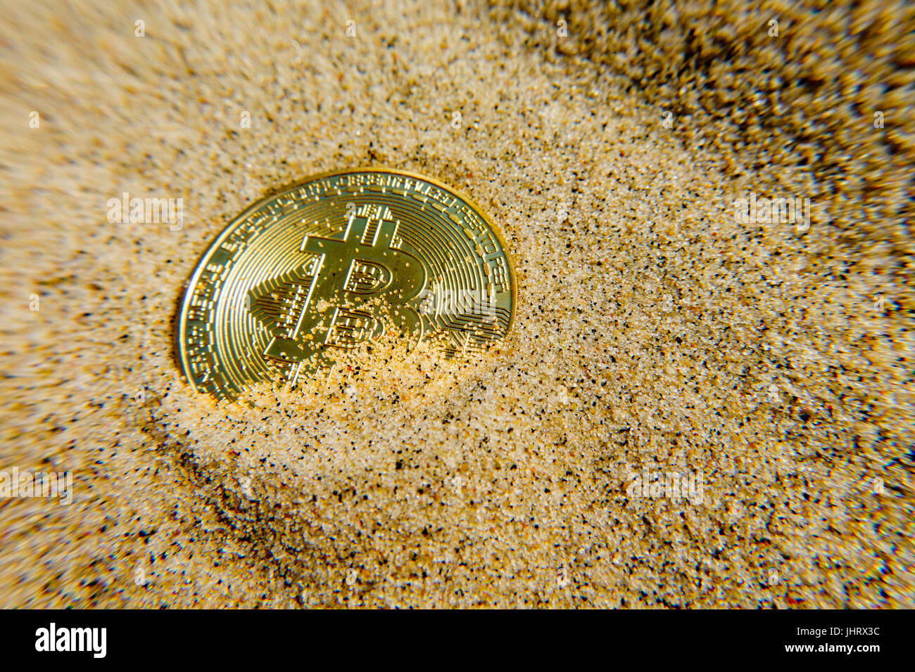 Golden bitcoin coin is in the sand Stock Photo - Alamy