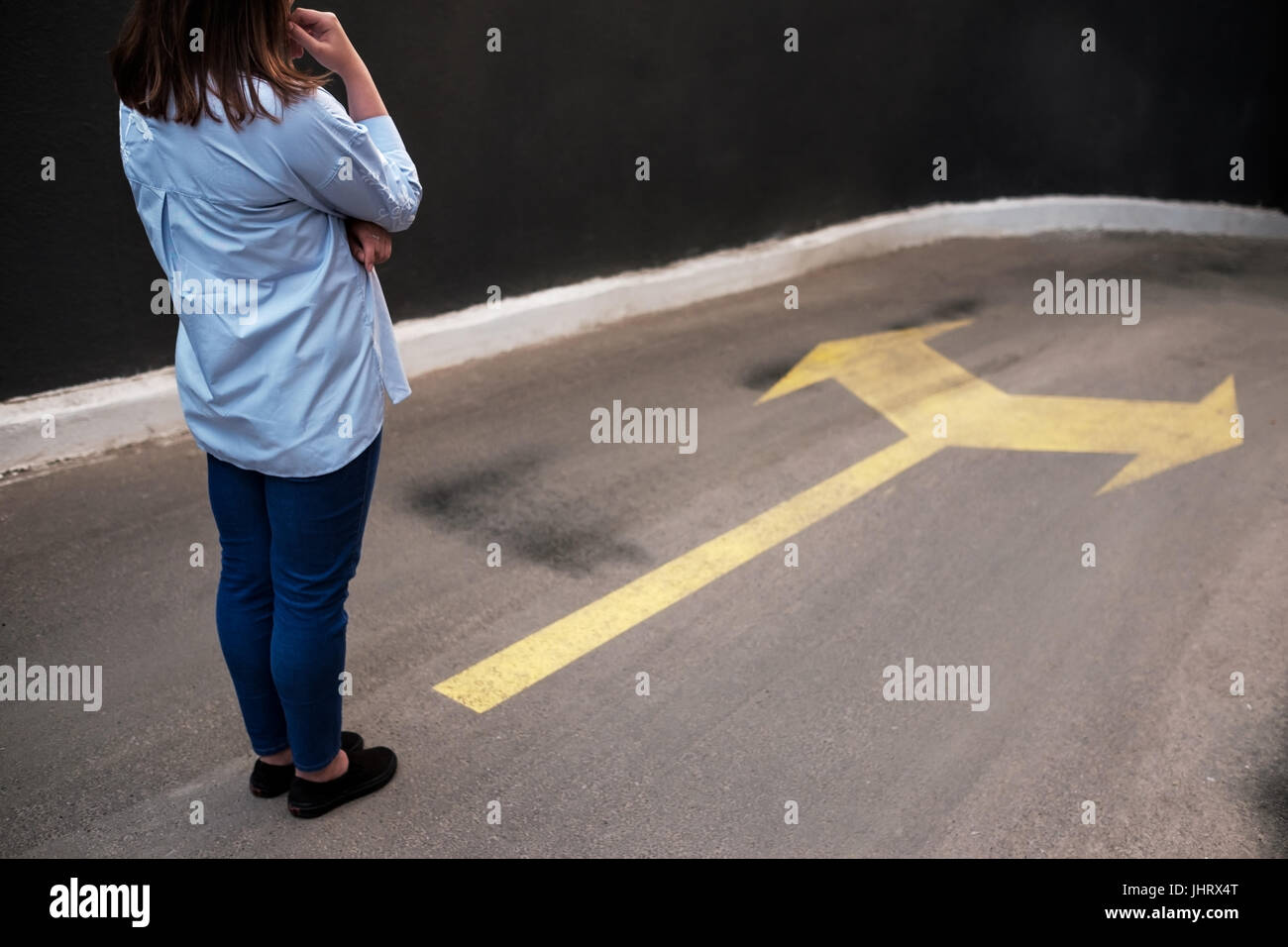 Young woman standing in front of two roads Stock Photo - Alamy
