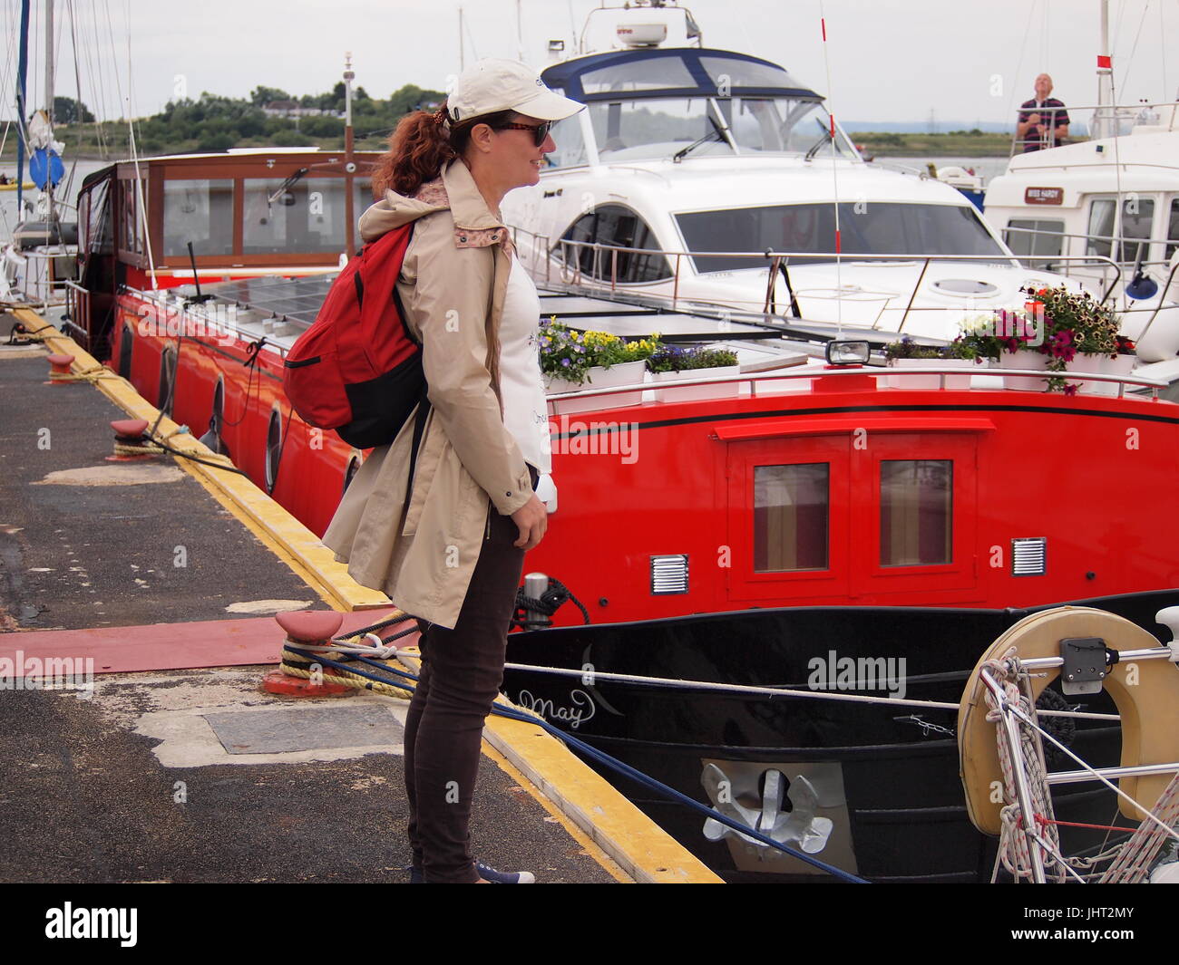 Woman with a red ruck sack standing near a red house boat Stock Photo ...