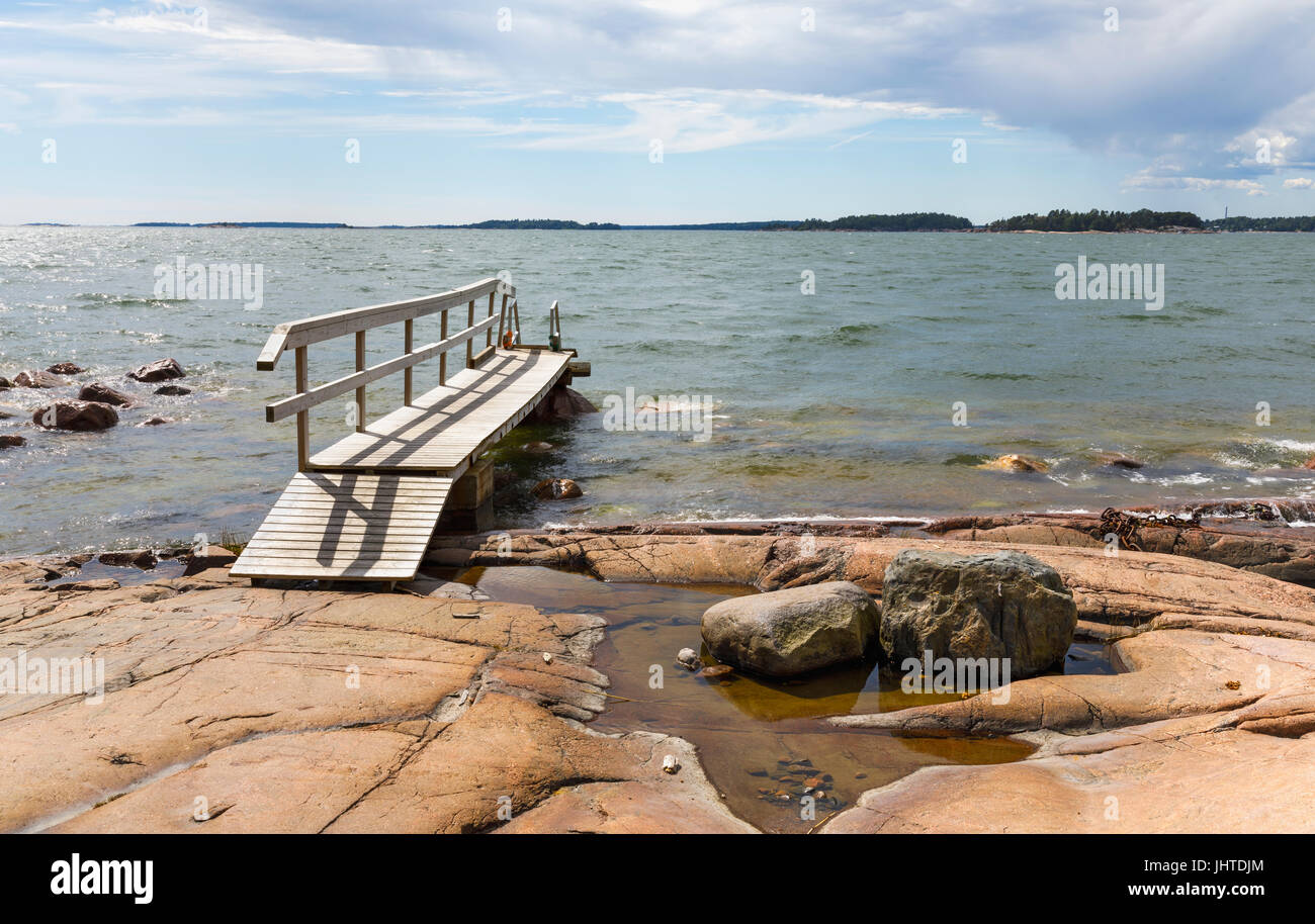 Small wooden foot bridge over rocks leads into the sea Stock Photo - Alamy