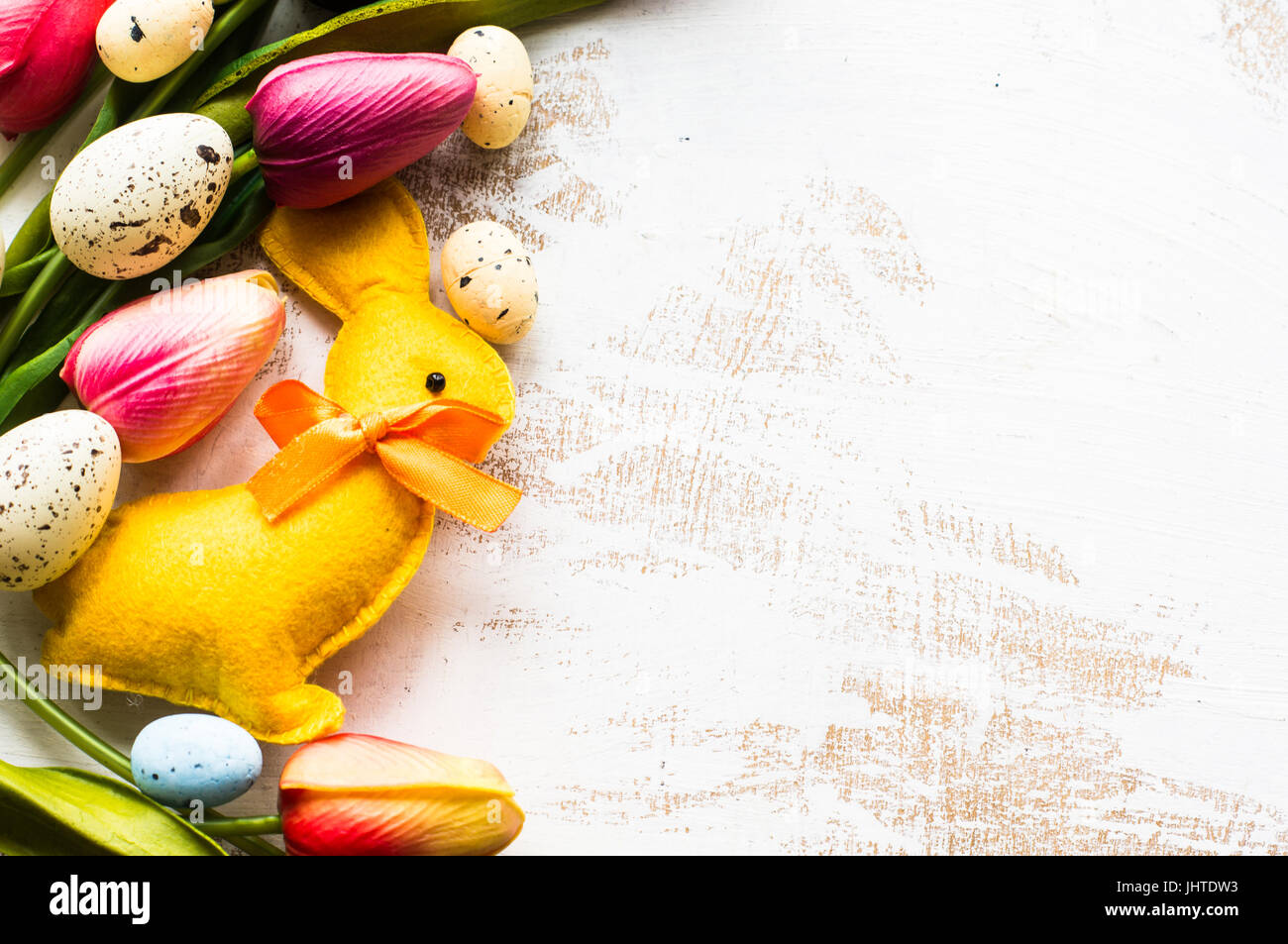 Easter festive frame with eggs, tulips and easter bunny on white rustic ...