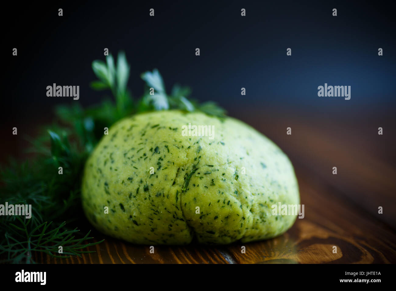 Green dough with dill and parsley on a wooden table Stock Photo - Alamy