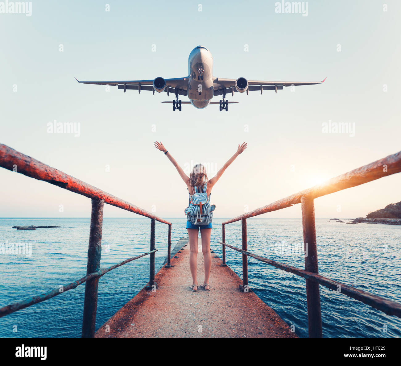 Airplane and woman at sunset. Summer landscape with girl standing on ...