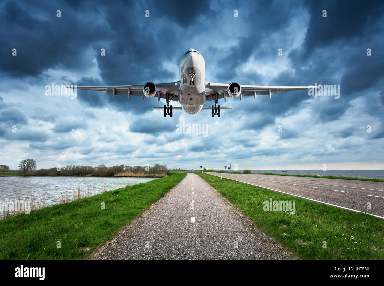 Airplane and road. Landscape with passenger airplane is flying over the ...
