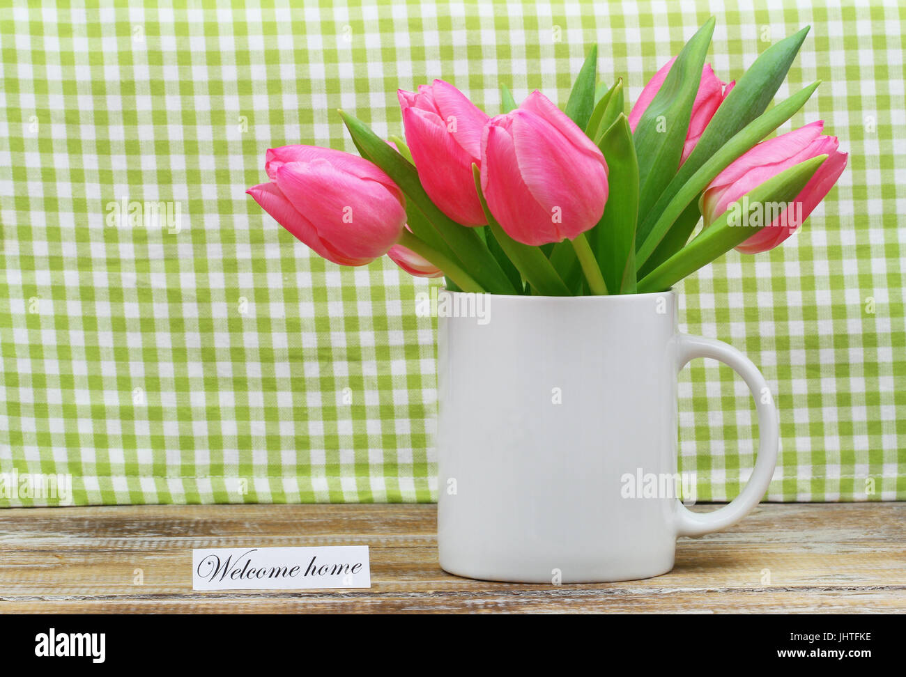 Welcome home card with mug full of pink tulip flowers on checkered ...