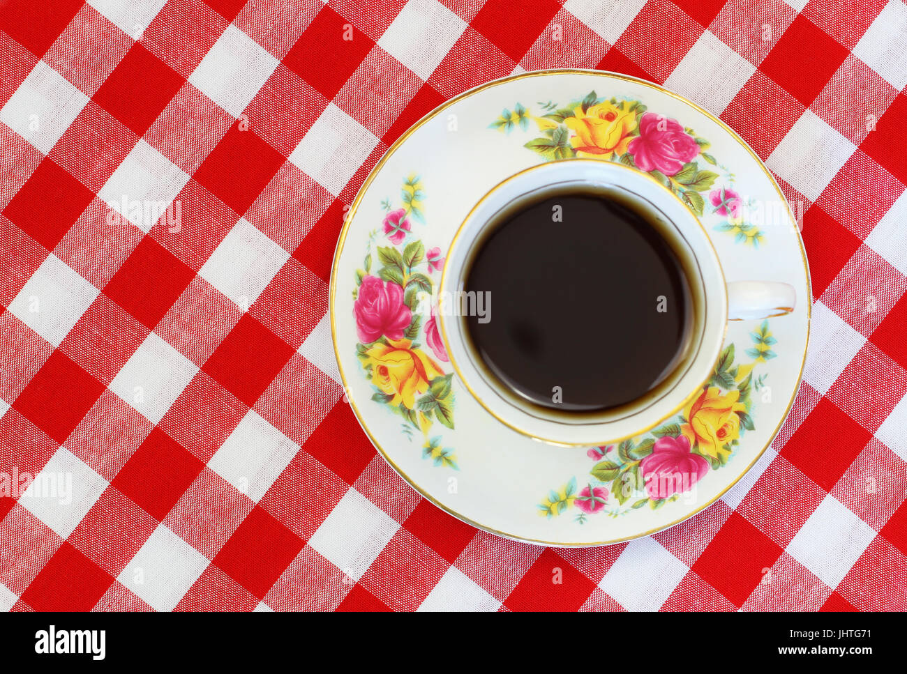 Cup of black tea in vintage cup on red and white checkered cloth with ...