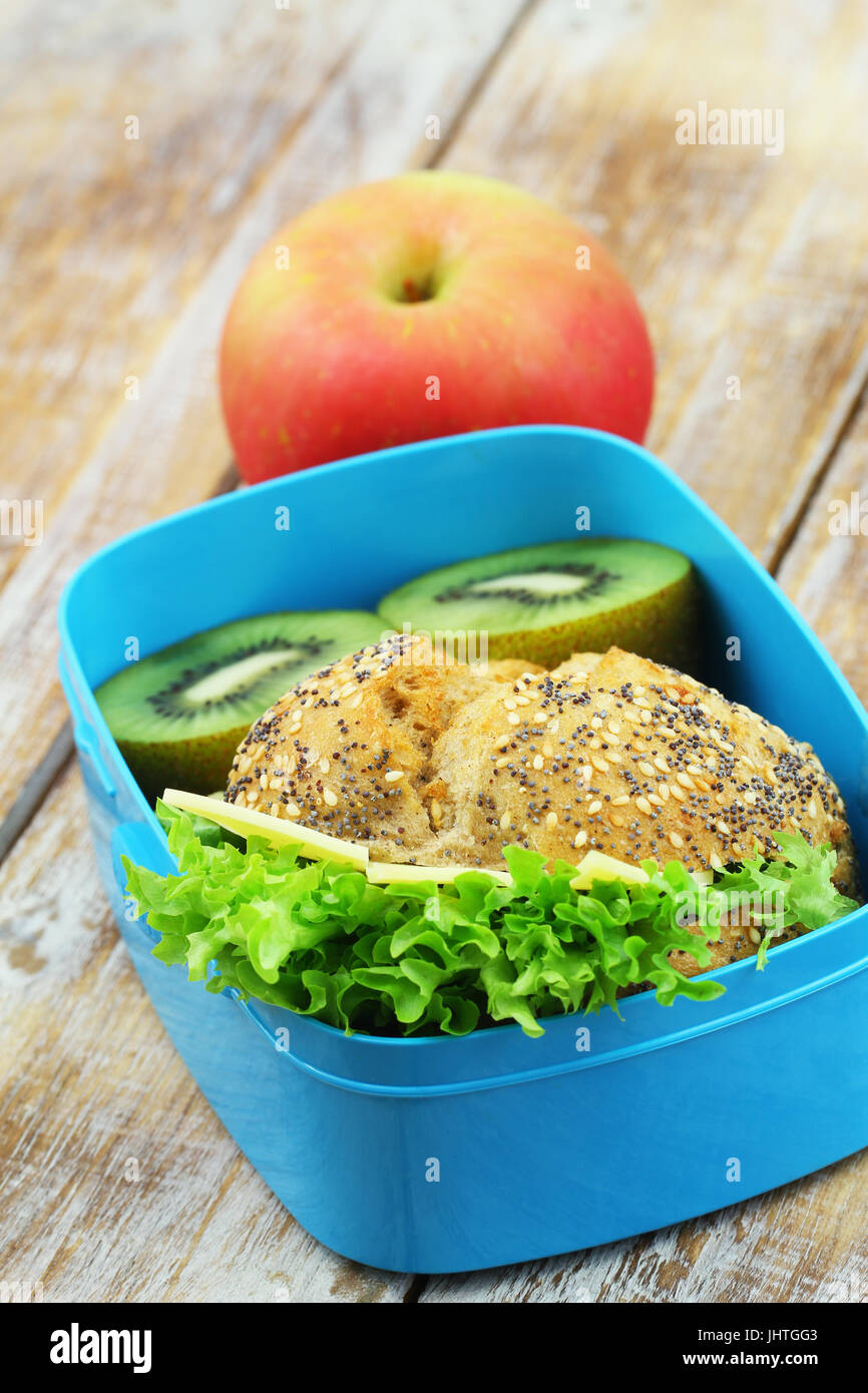 School lunch box containing wholegrain cheese roll with lettuce, kiwi ...