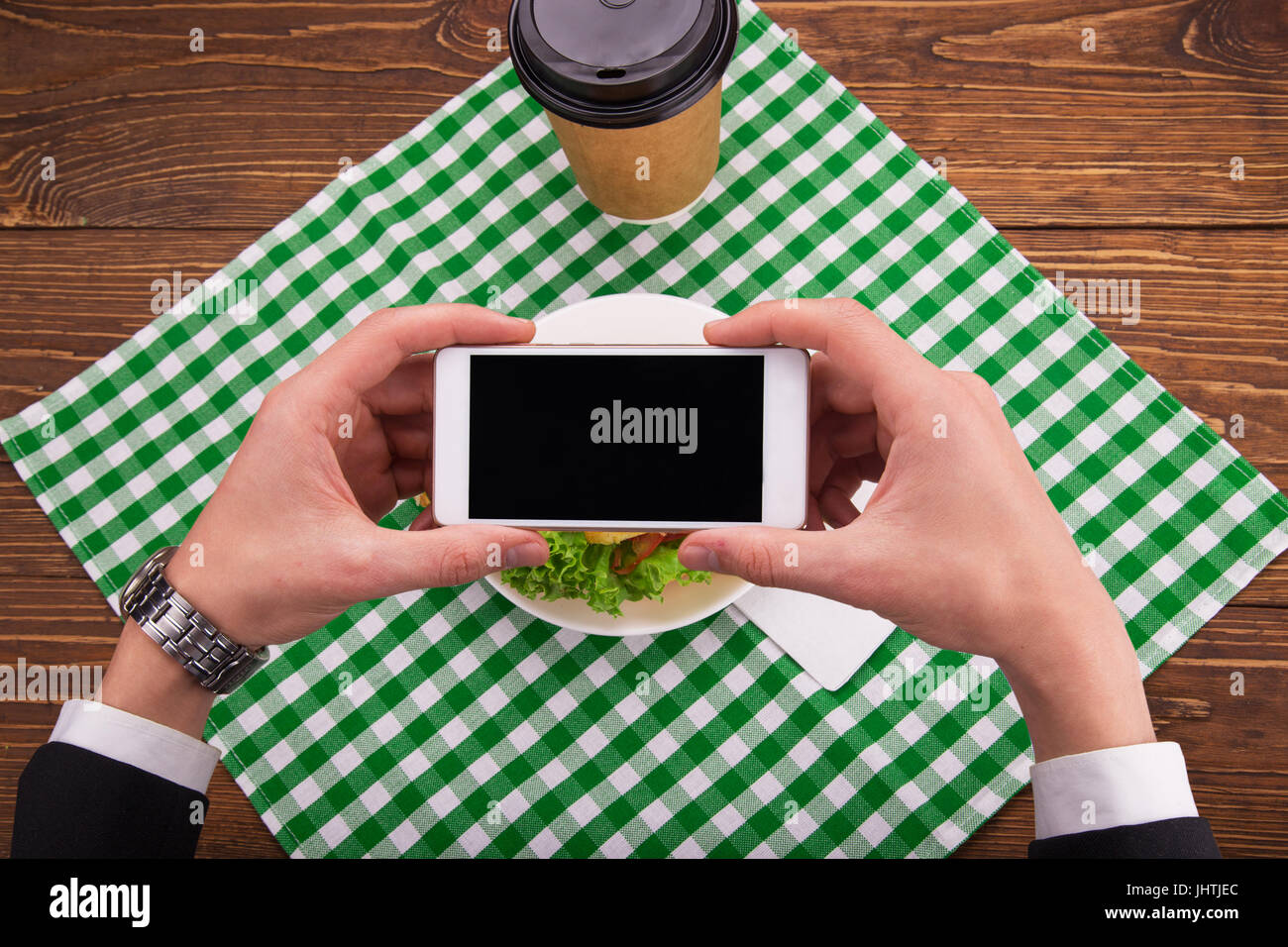 taking photo of meat sandwich on mobile phone. Business lunch concept ...