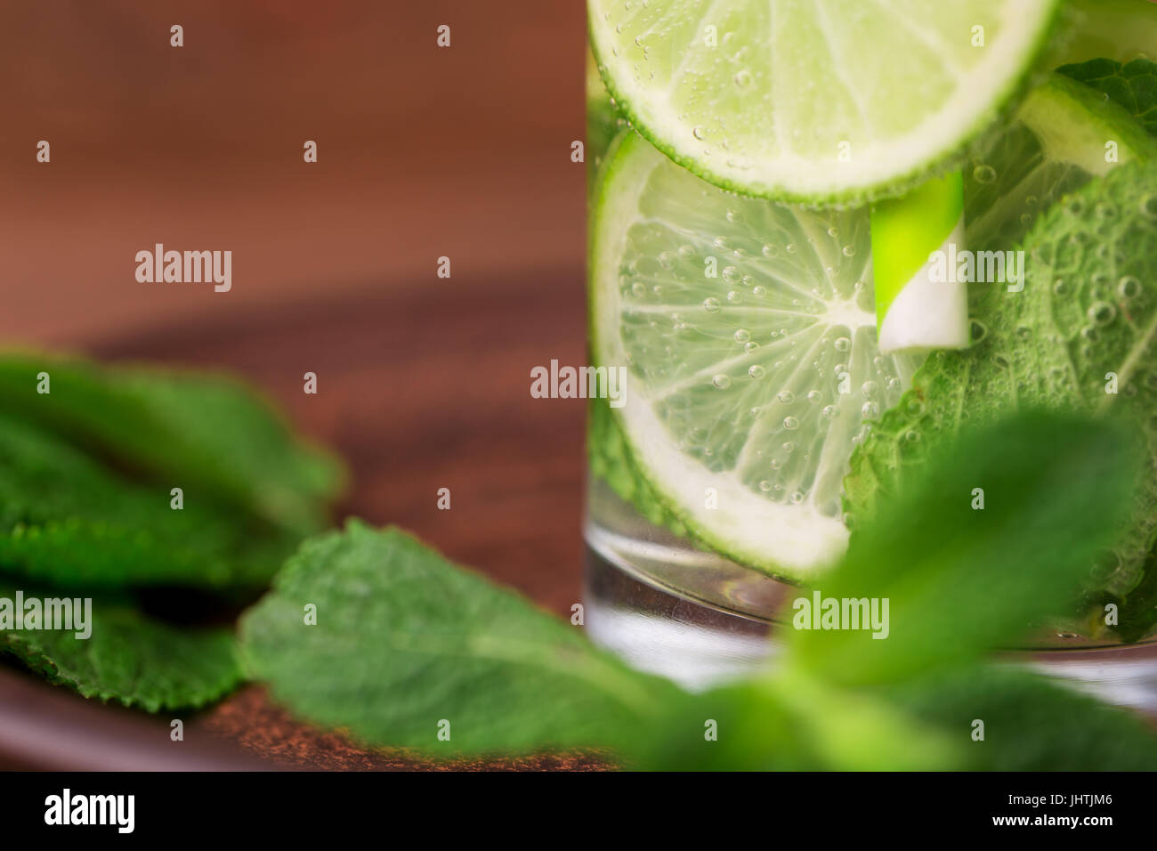 Detox water with lime and mint in glass. Mojito cocktail. on a wooden ...