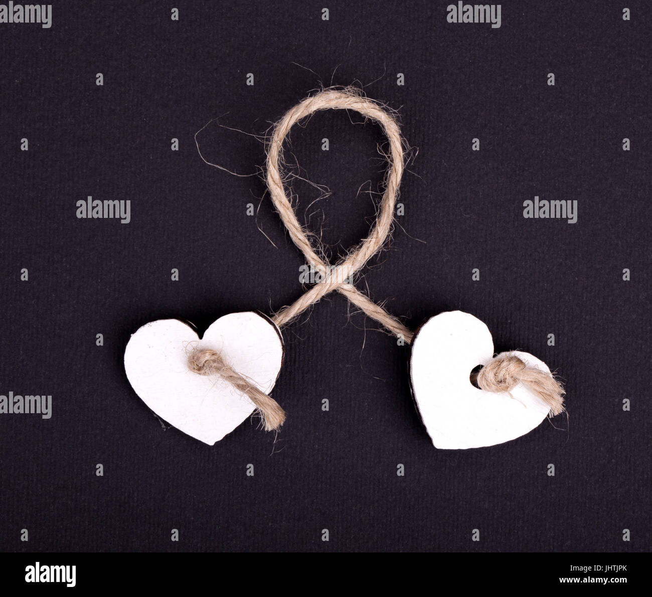 Two white hearts together bound with rope, concept of love and marriage ...