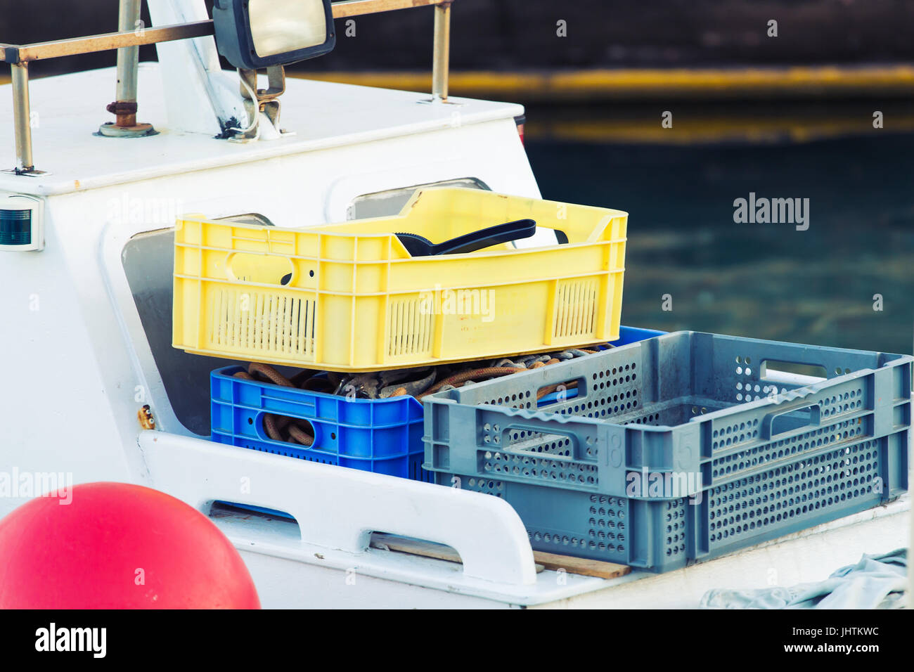 Coloured containers for fish on fishing boat Stock Photo - Alamy