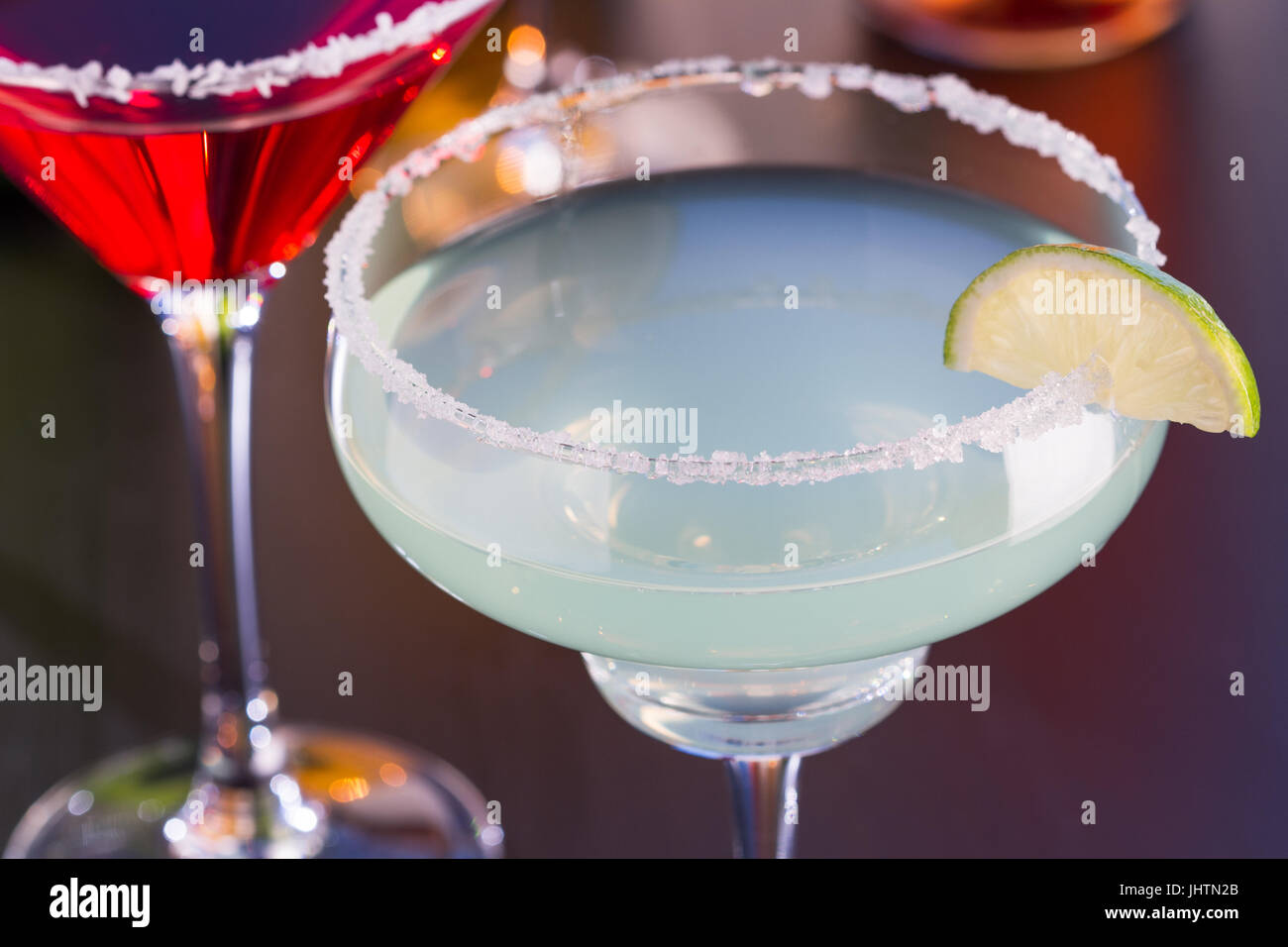 Tropical cocktail garnished with lime slice Stock Photo - Alamy