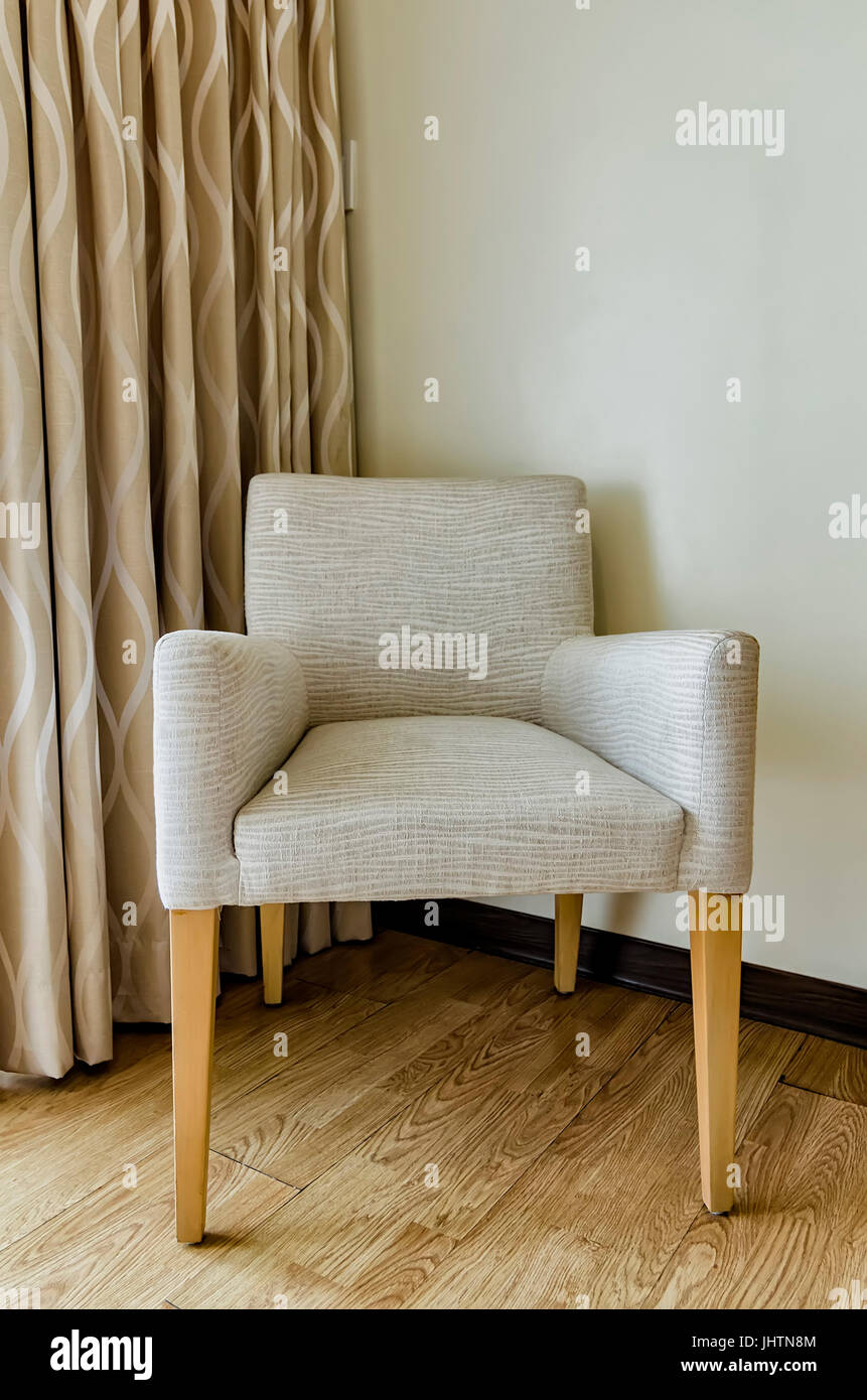Single comfortable chair beside window with curtain Stock Photo - Alamy