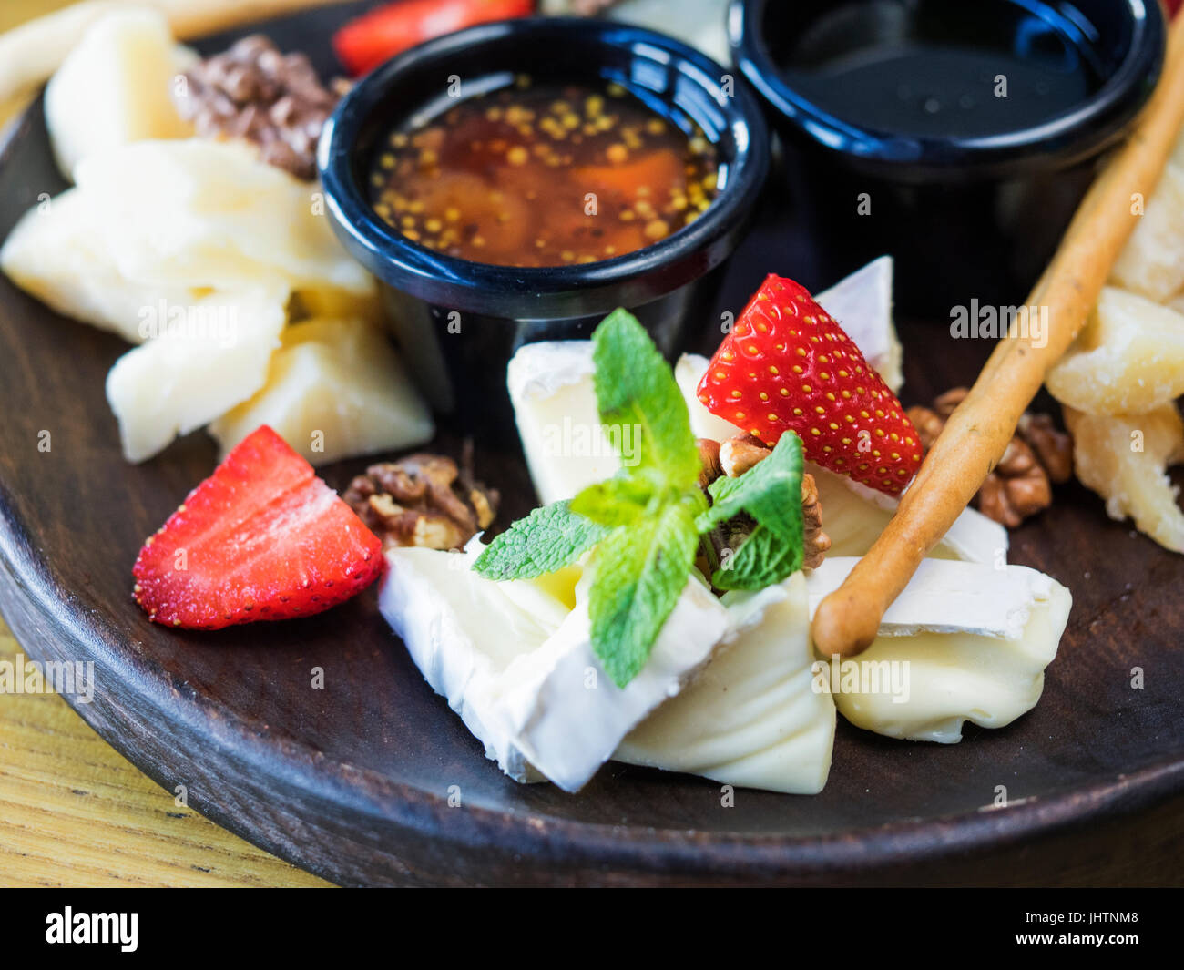 Italian chesse plate on black dish Stock Photo - Alamy