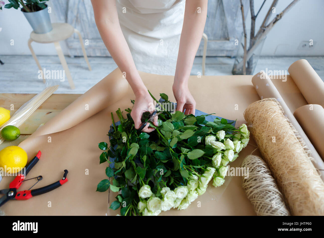 Woman makes bouquet on table Stock Photo - Alamy
