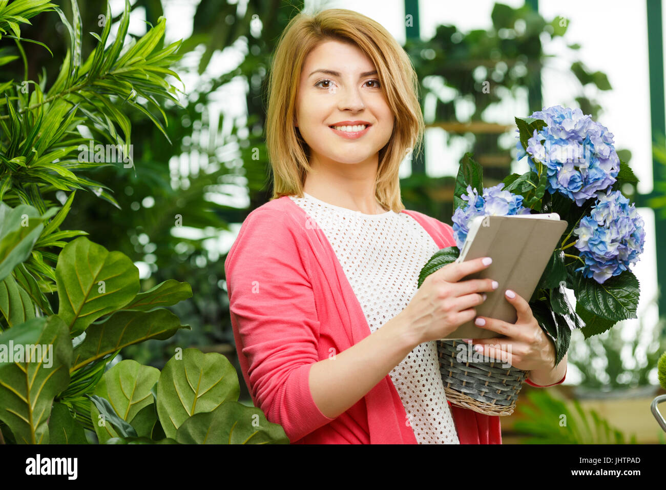 Florist with bouquet holds tablet Stock Photo - Alamy