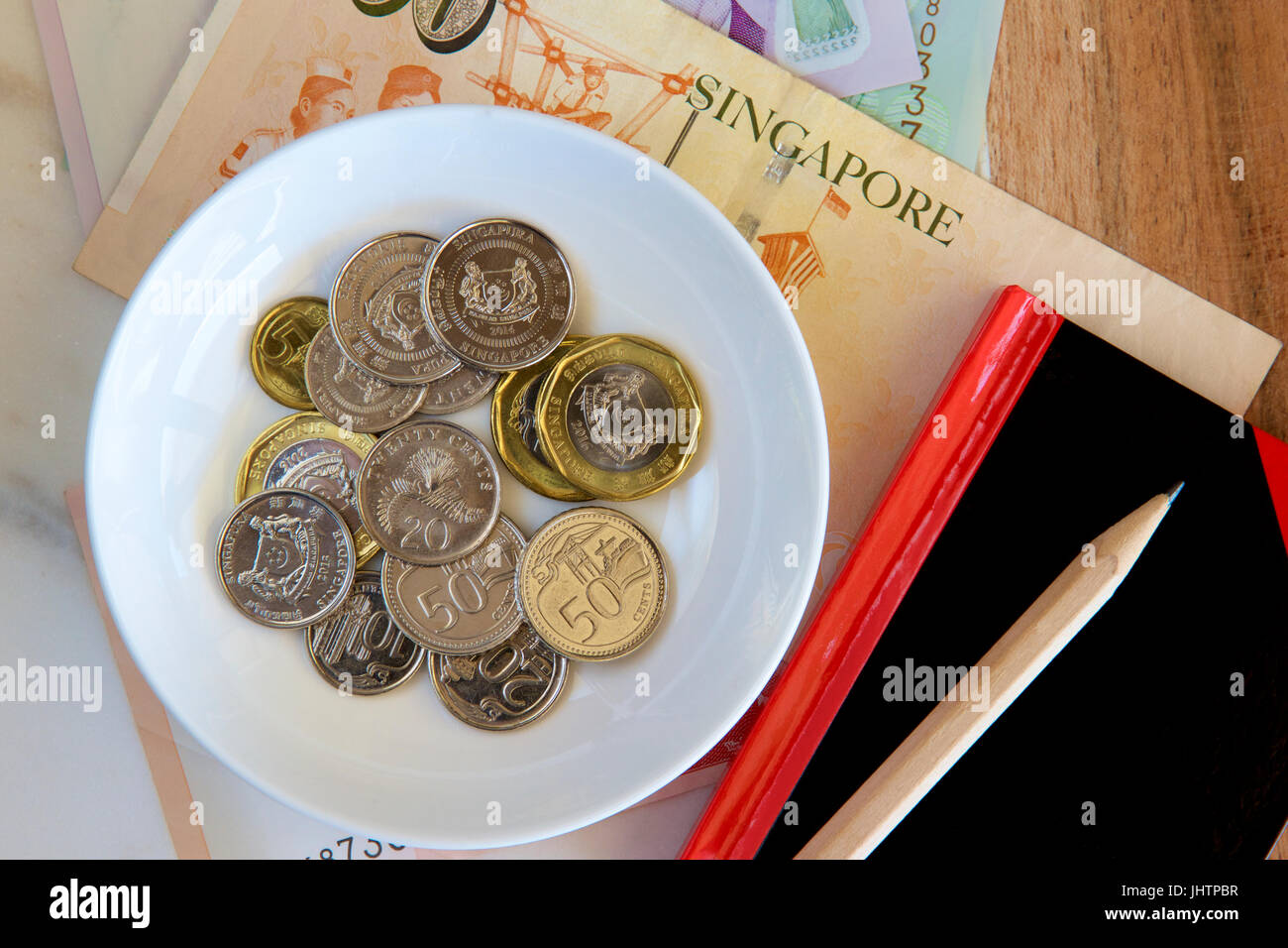 Singaporean notes, coins and a notebook with a pencil Stock Photo - Alamy