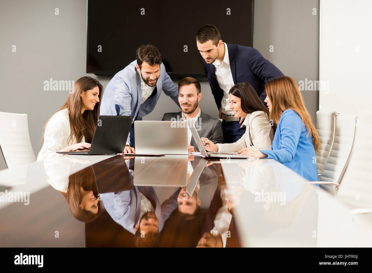 Young teamwork by the table in the office Stock Photo - Alamy