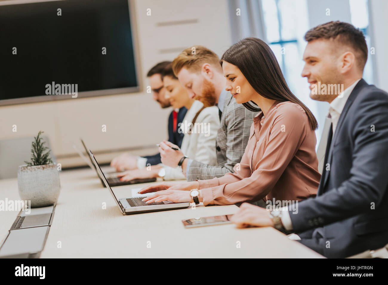 Young teamwork by the table in the office Stock Photo - Alamy