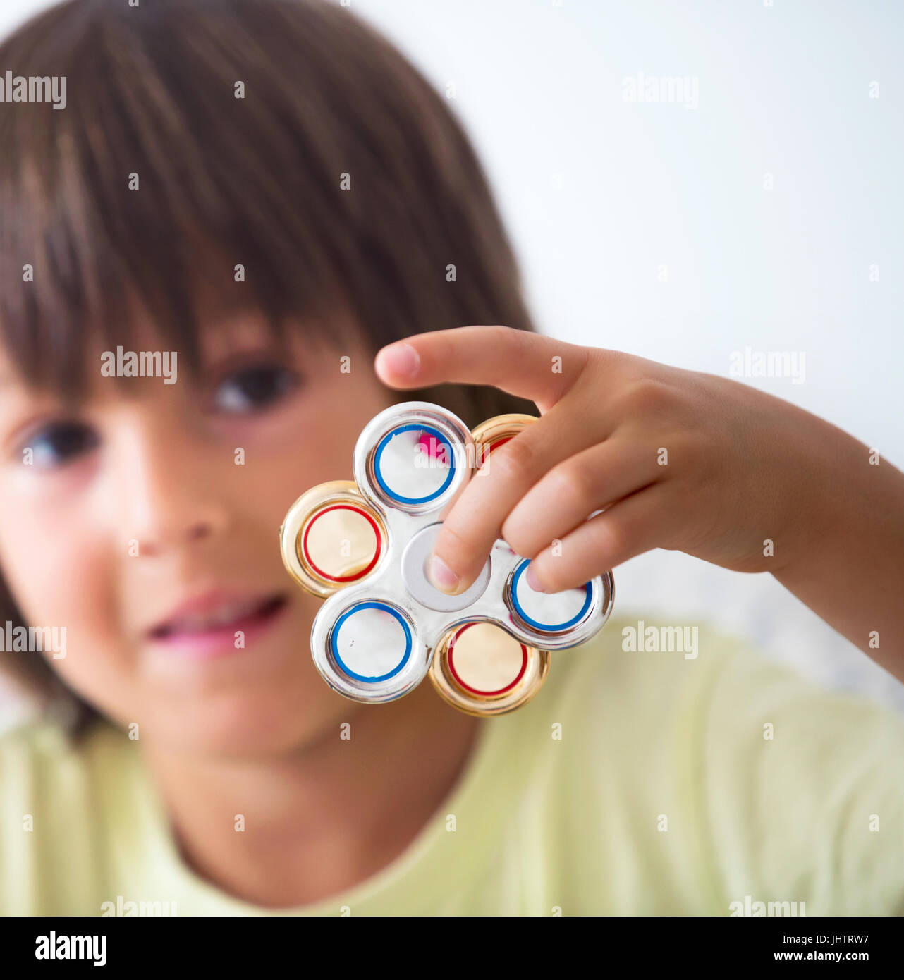 Young boy play with fidget spinner stress relieving toy at home Stock ...