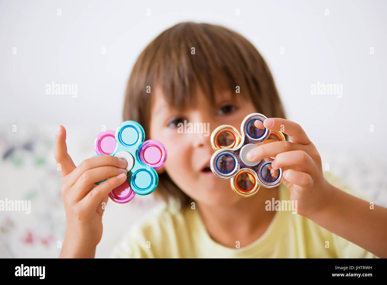 Young boy play with fidget spinner stress relieving toy at home Stock ...