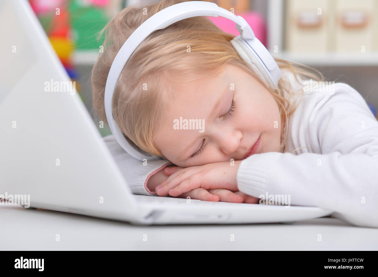Cute little girl sleeping near laptop Stock Photo - Alamy