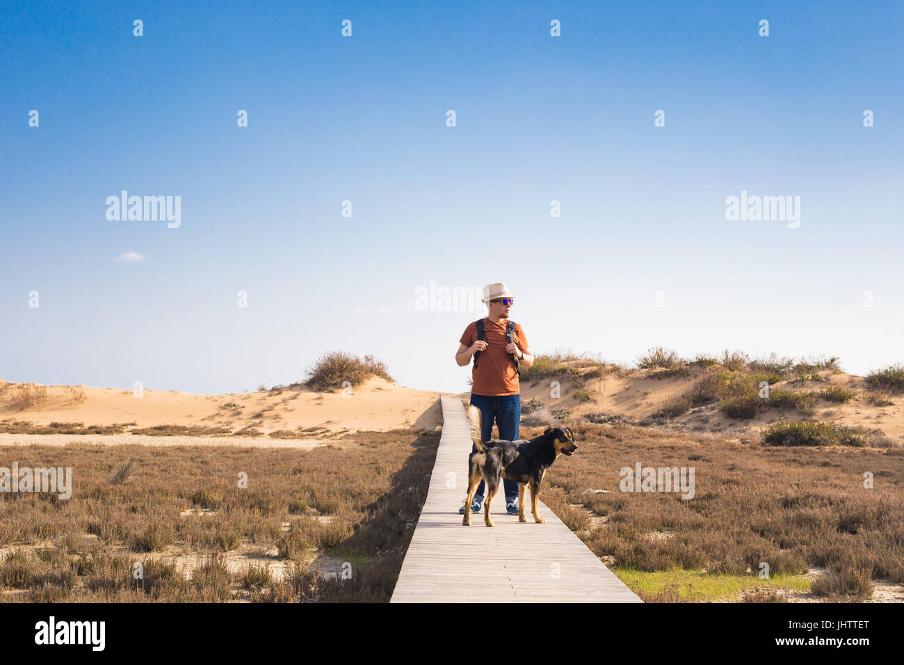 Man walking with his dog on a road leading through beautiful landscape ...
