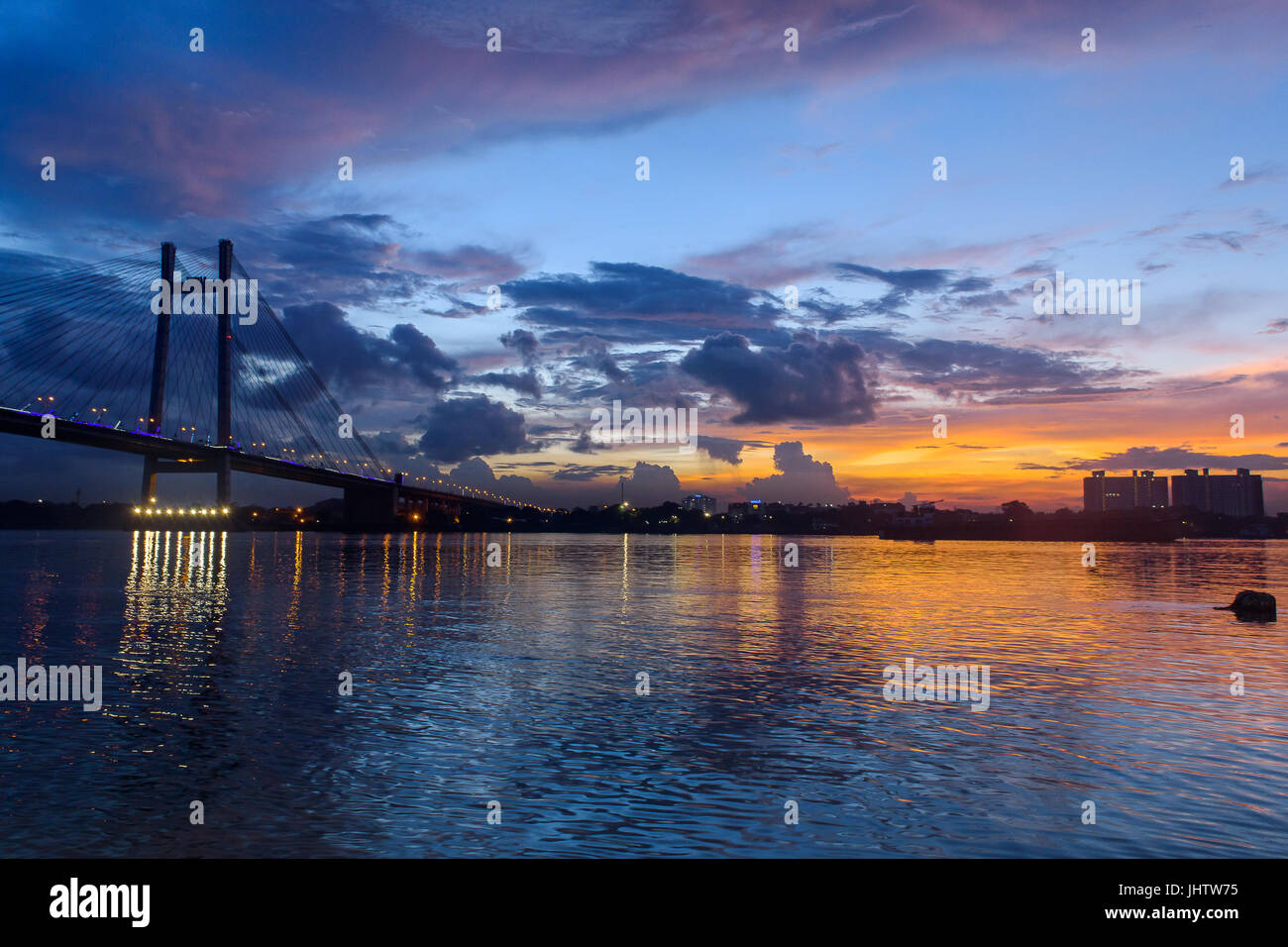 Silhouette of Vidyasagar Setu bridge at twilight with a wooden boat on ...