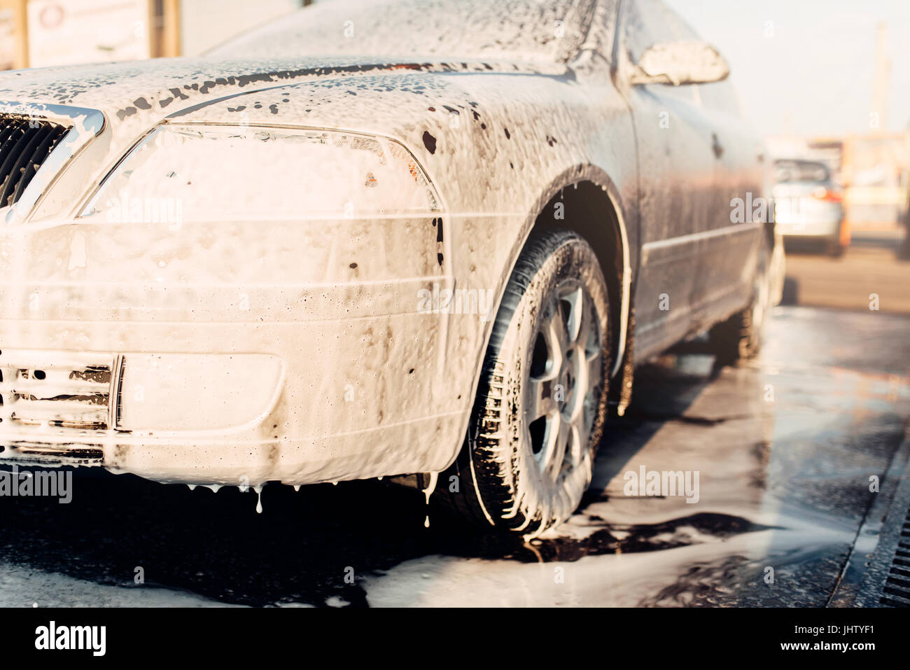 Wet vehicle in foam, automobile in suds, car wash. Carwash station ...