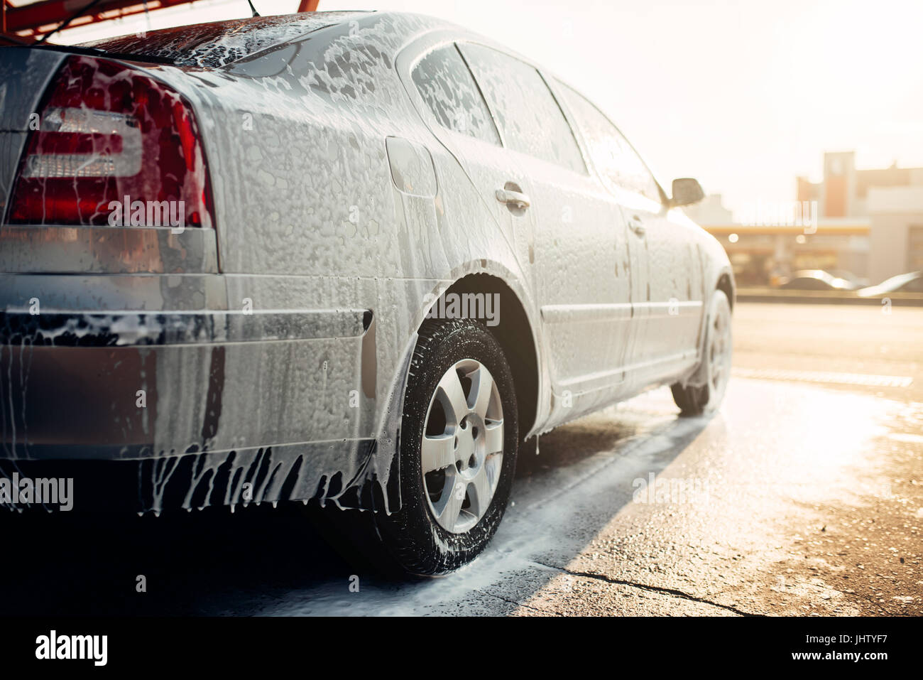 Wet vehicle in foam, automobile in suds, car wash. Carwash station ...