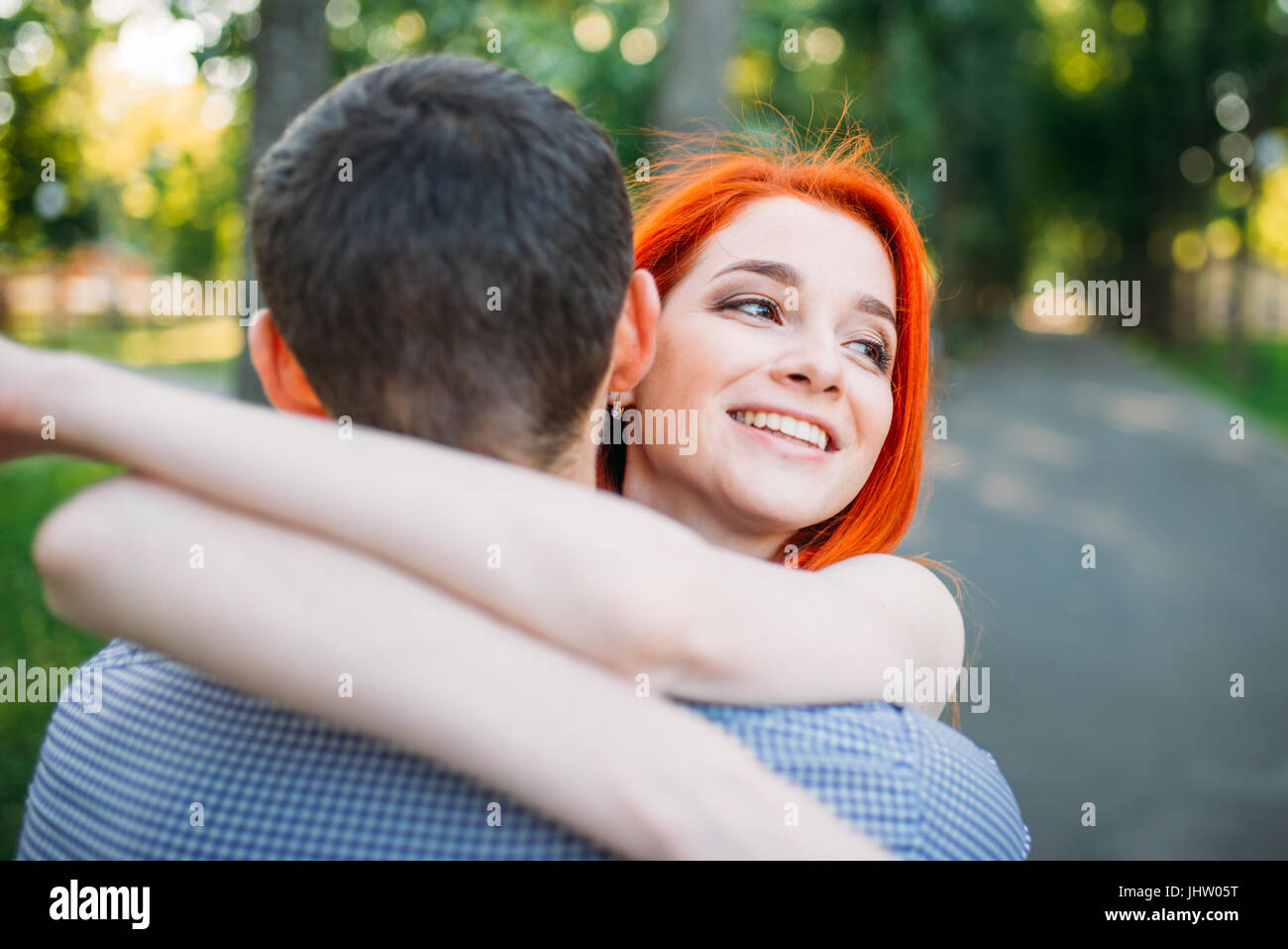 Romantic meeting, young couple hugs together in green summer park. Man ...