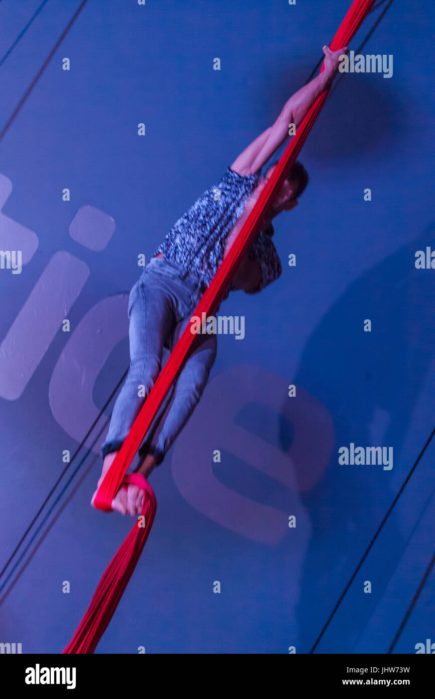 acrobats hanging on a rope by their legs Stock Photo - Alamy
