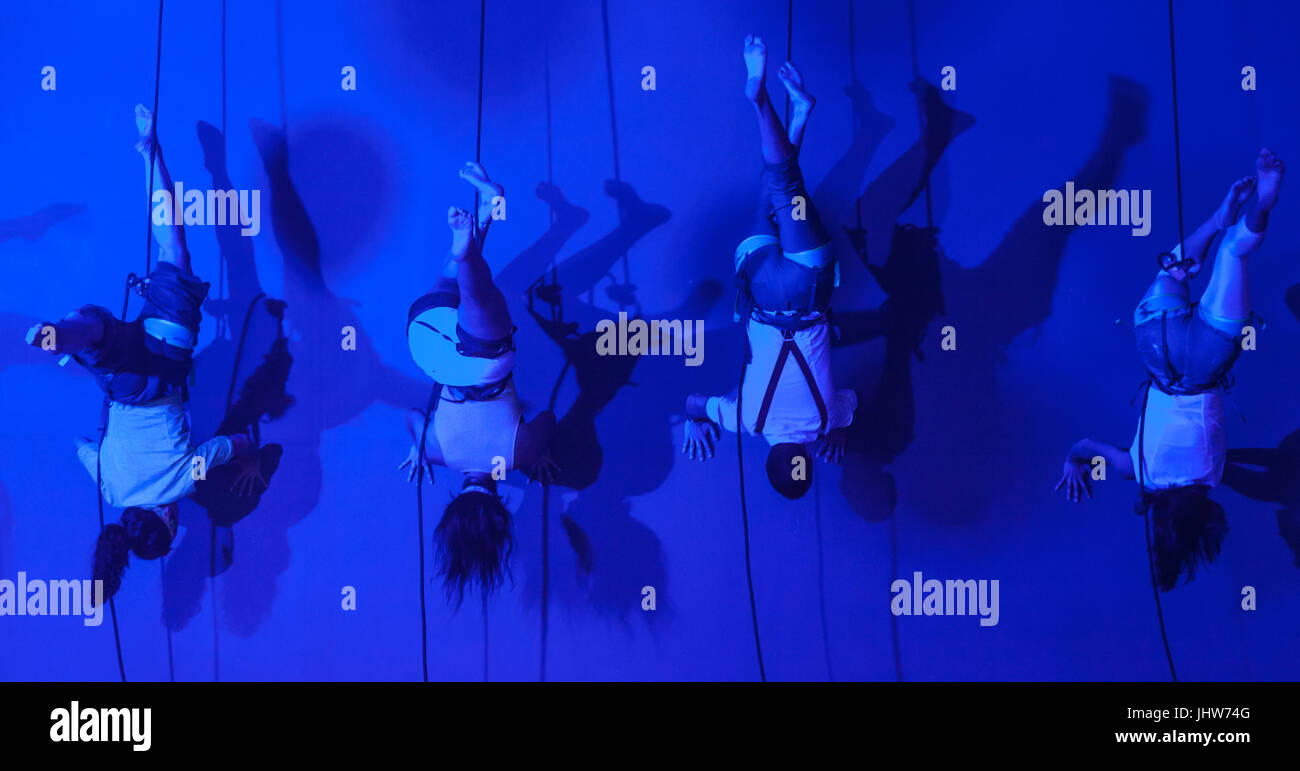 acrobats hanging on a rope by their legs Stock Photo - Alamy