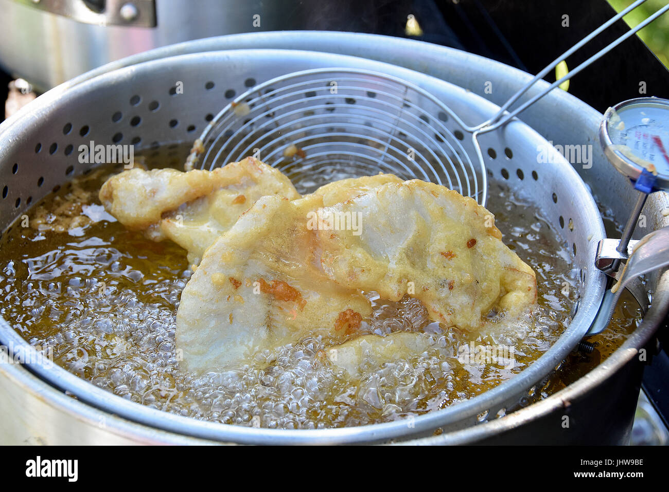 perch fish fillets in deep fryer with strainer Stock Photo - Alamy