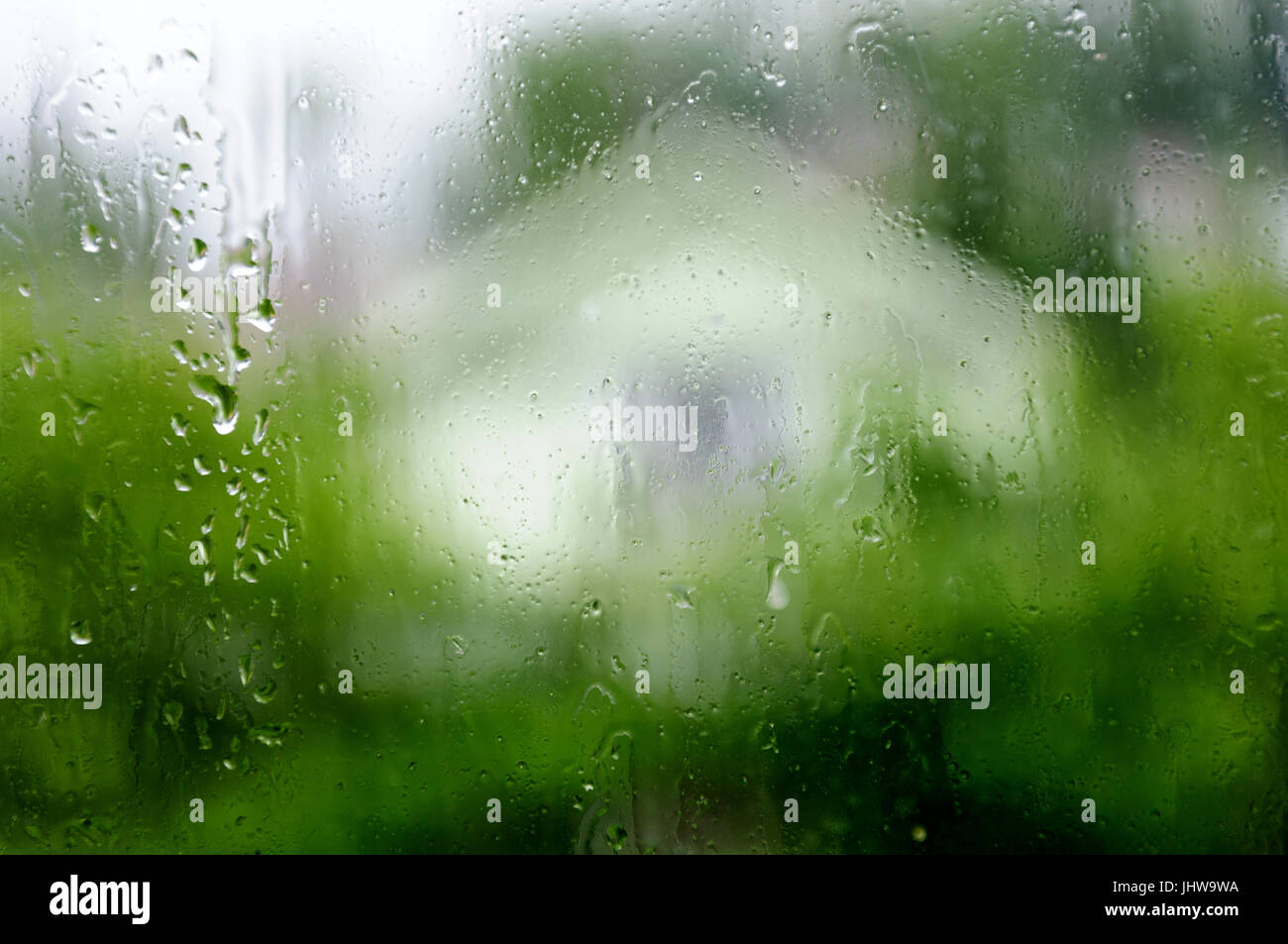 Wet window with drops, countryside, blur background Stock Photo - Alamy