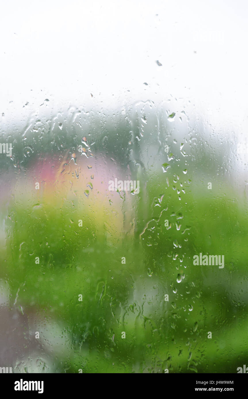 Wet window with drops, countryside, blur background Stock Photo - Alamy