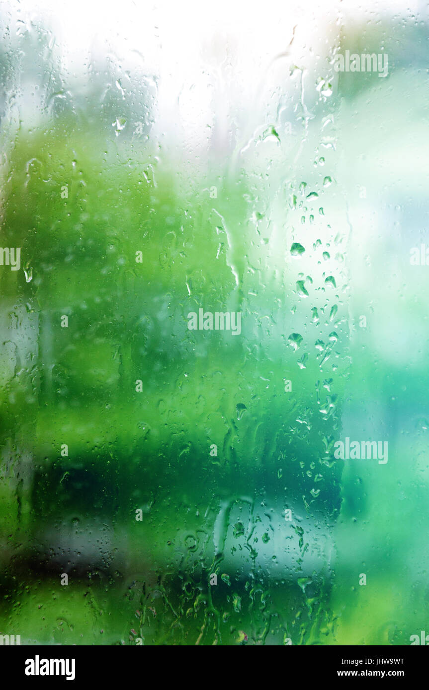 Wet window with drops, countryside, blur background Stock Photo - Alamy
