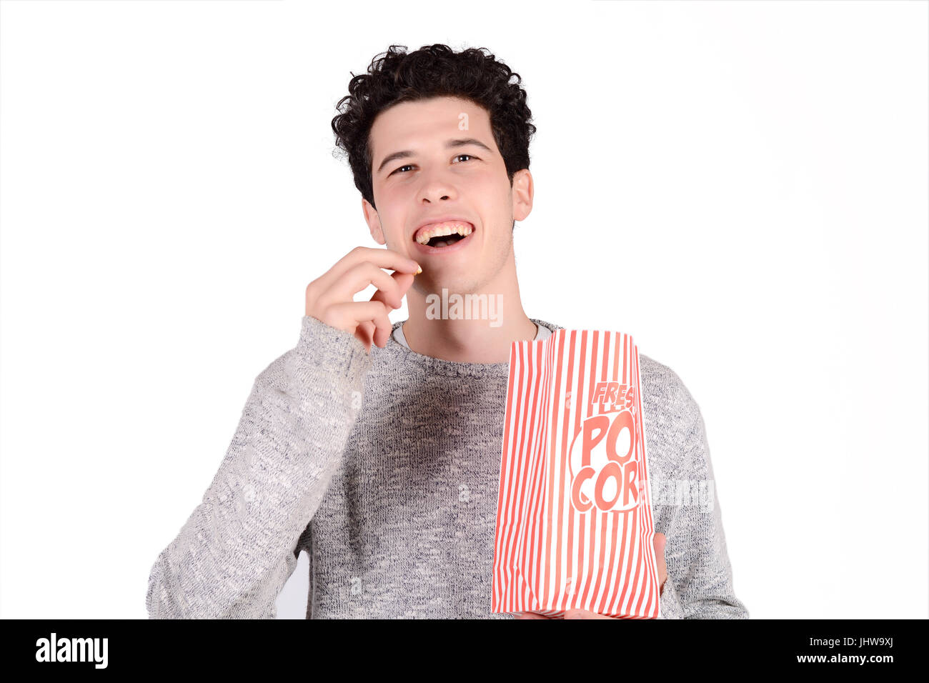 Portrait of young man eating popcorn. Isolated white background Stock ...