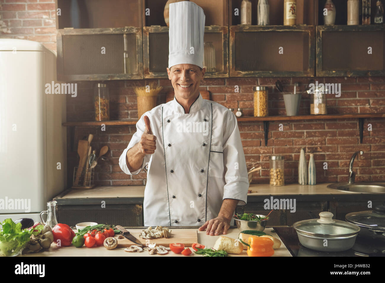 Mature man professional chef cooking meal indoors Stock Photo - Alamy