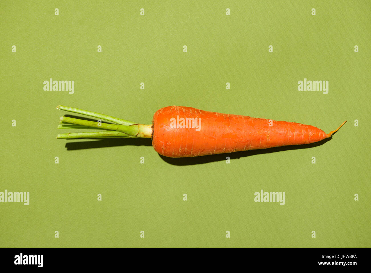 Top view of an carrot on green background Stock Photo - Alamy