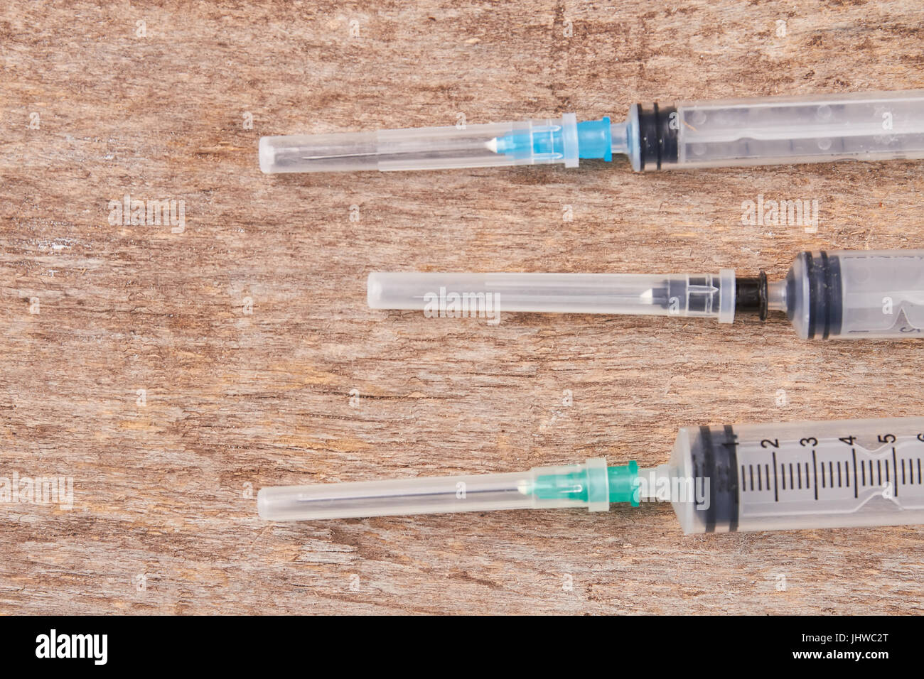 Injection needle syringes, wooden background Stock Photo - Alamy