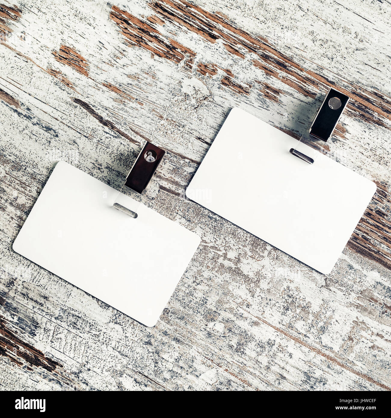 Photo of blank white plastic badges on wood table background ...