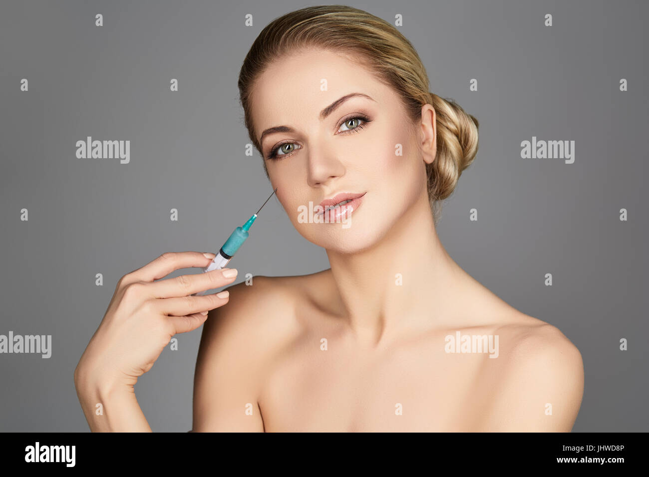 beautiful young woman holding syringe with collagen treatment injection ...