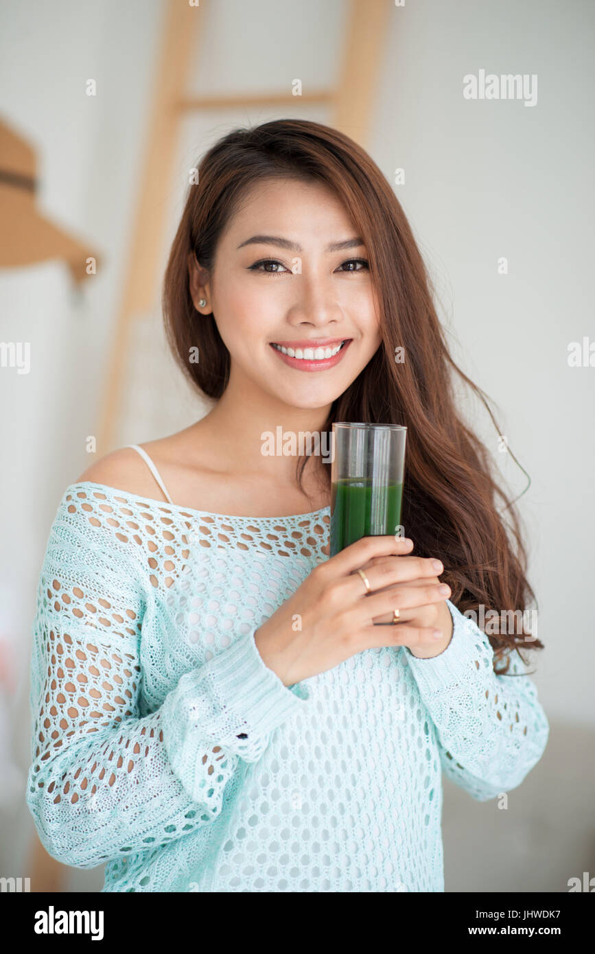 Pretty Young Asian Woman Drinking Green Fresh Vegetable Juice Or