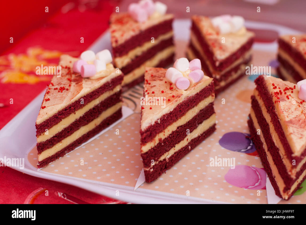 Triangular slices of chocolate and cream cakes with marshmallows on top ...