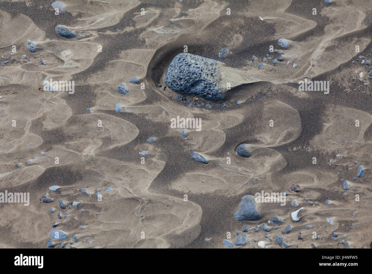 Wind patterns around small pebbles with fine sand Stock Photo - Alamy
