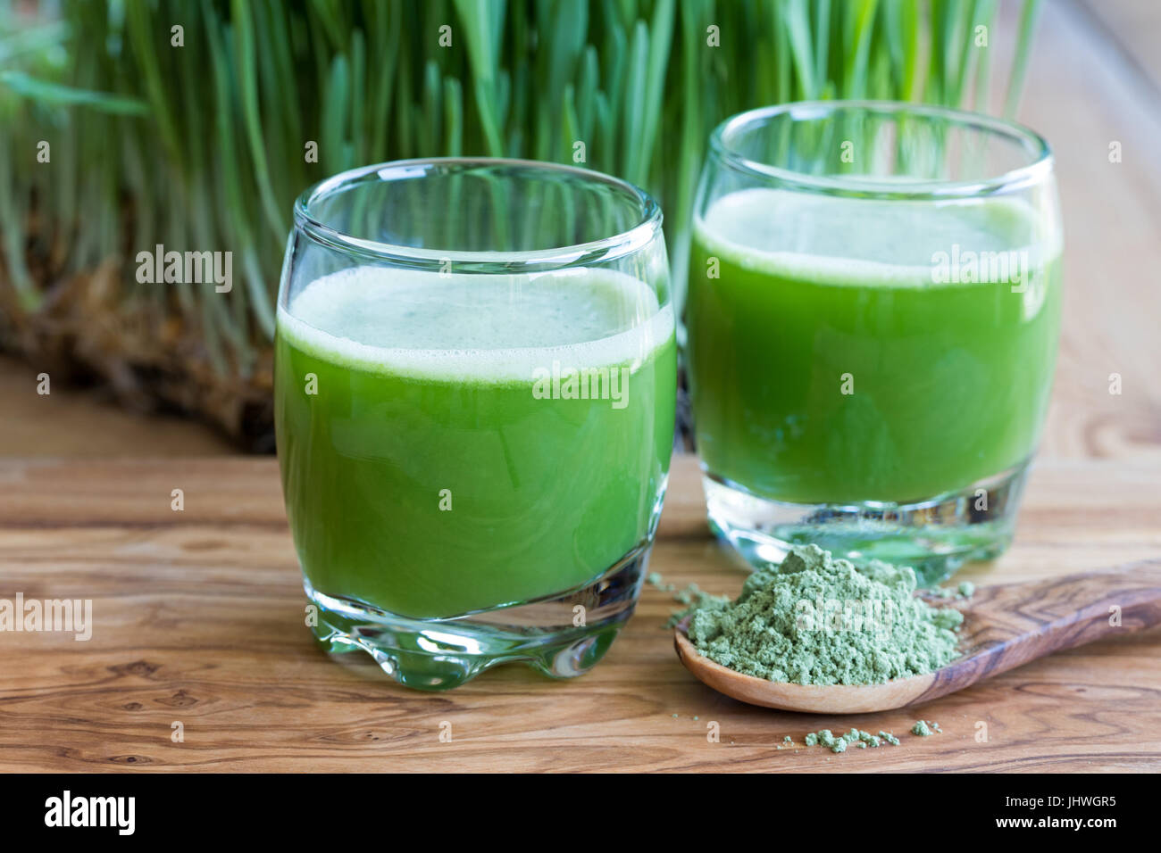 Two green barley grass shots on a wooden background, with fresh young ...