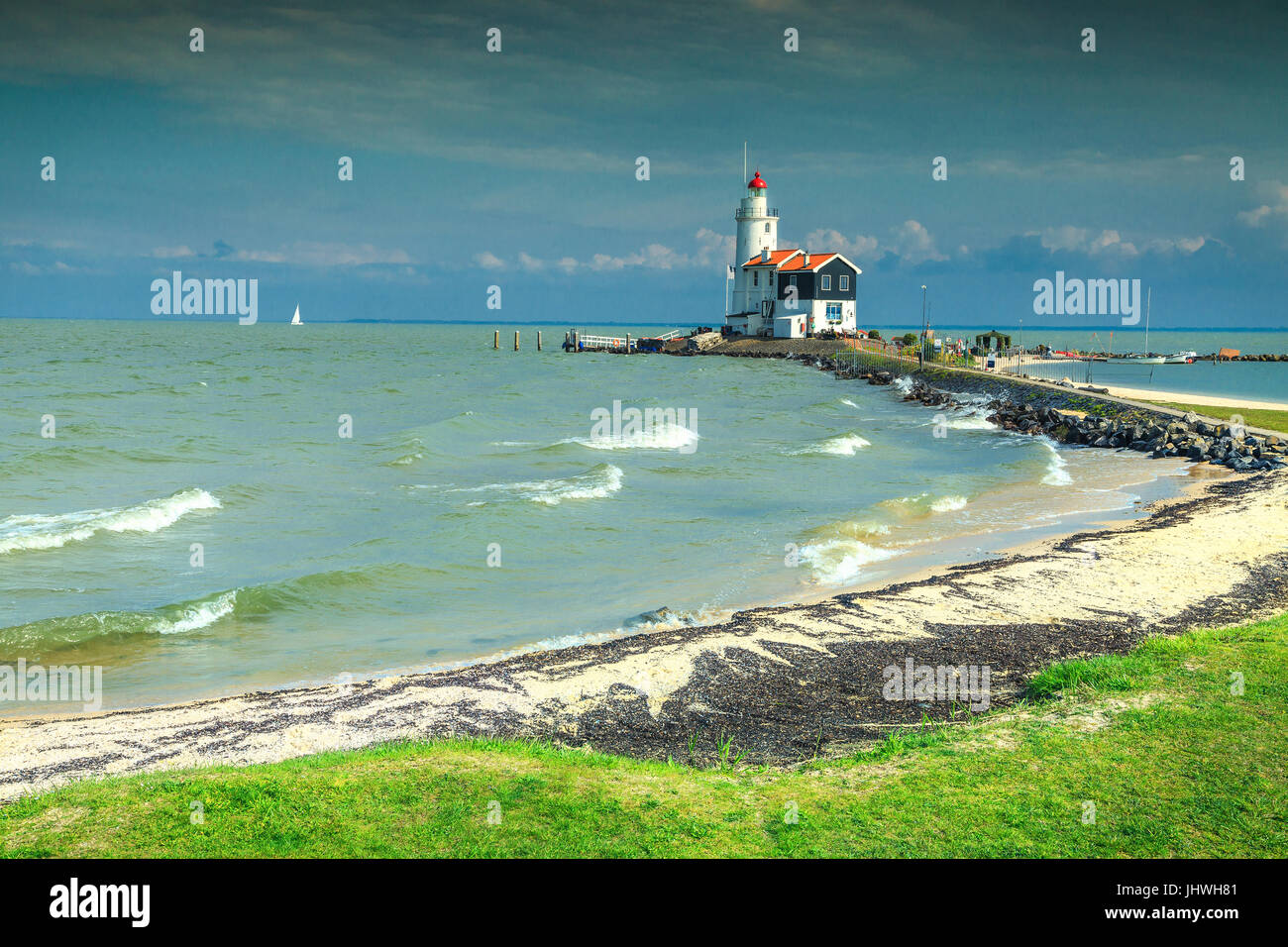 Amazing lighthouse on the island of Marken and stunning beach with sand ...