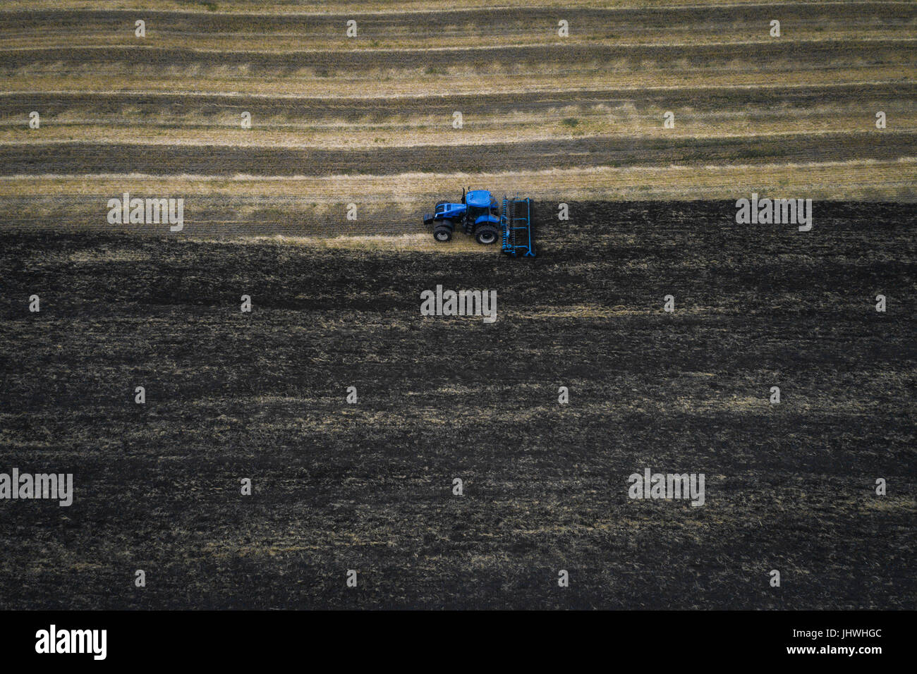 Tractor cultivating field at spring, aerial view Stock Photo - Alamy