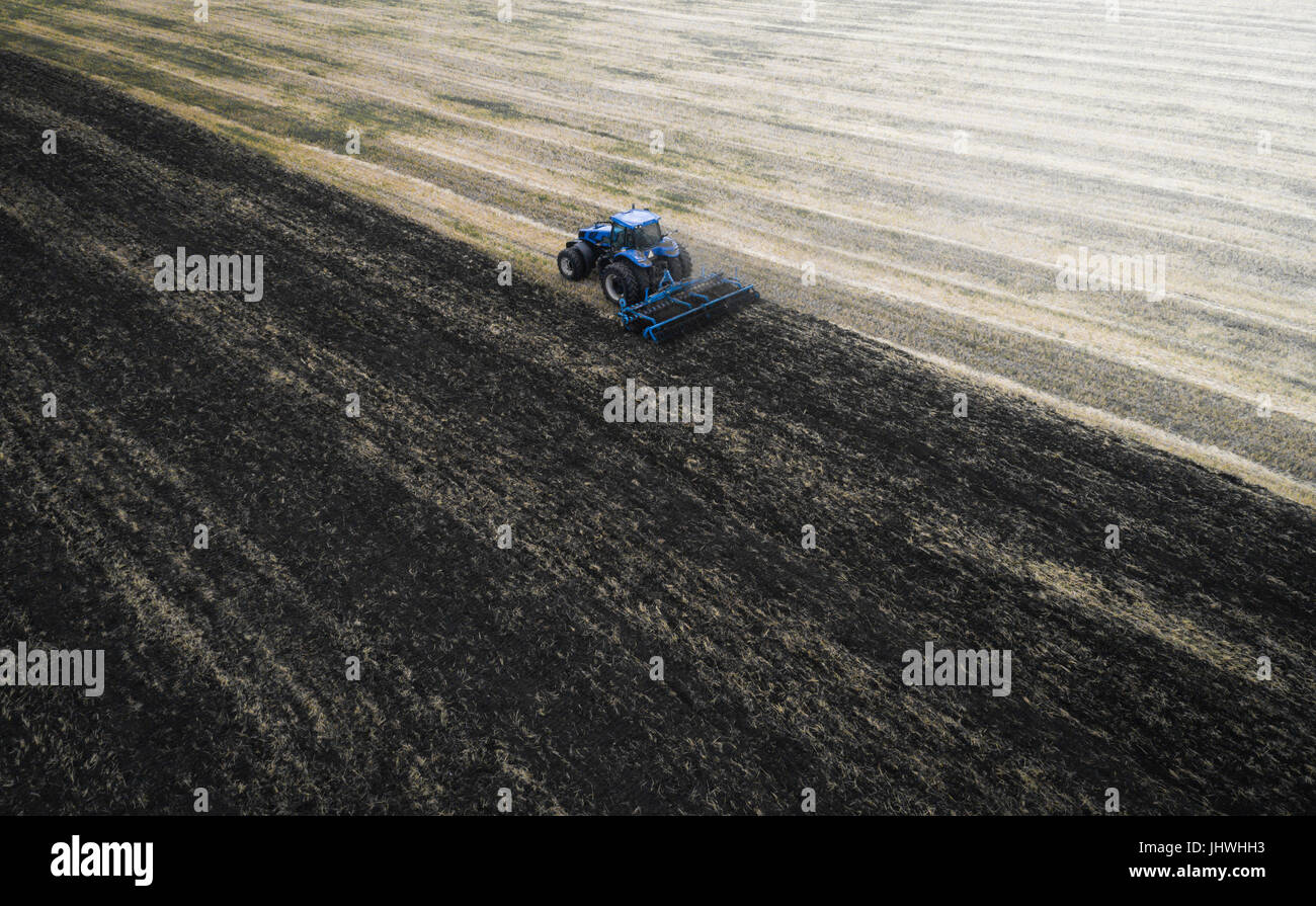 Tractor cultivating field at spring, aerial view Stock Photo - Alamy